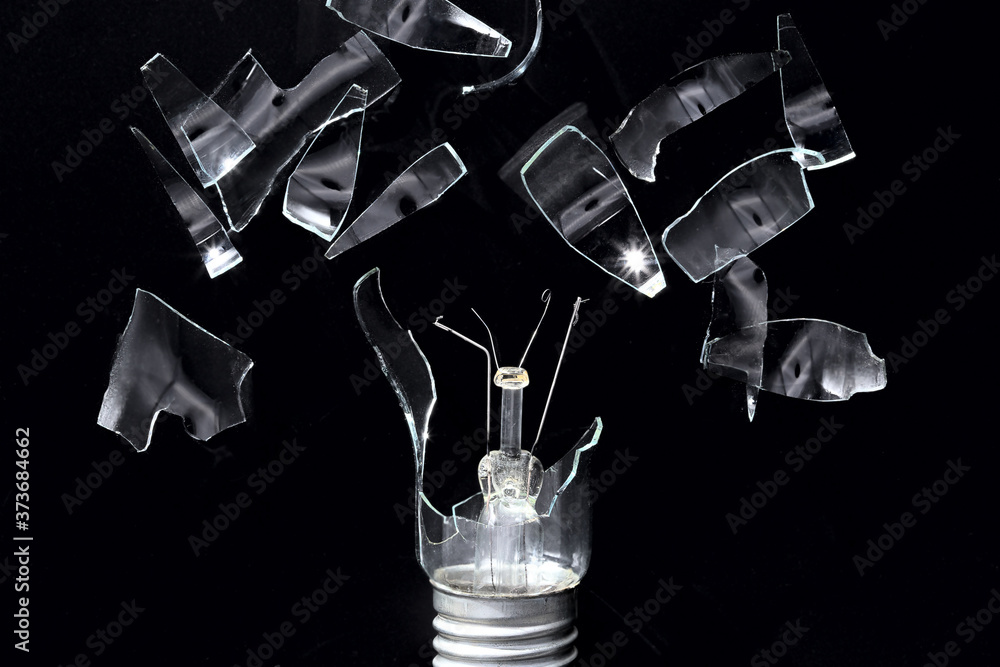Broken incandescent lamp. Glass shards. The glass shatters to the sides ...