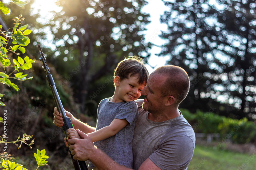 Cheerful young father teaching his cute little four years old son to ...