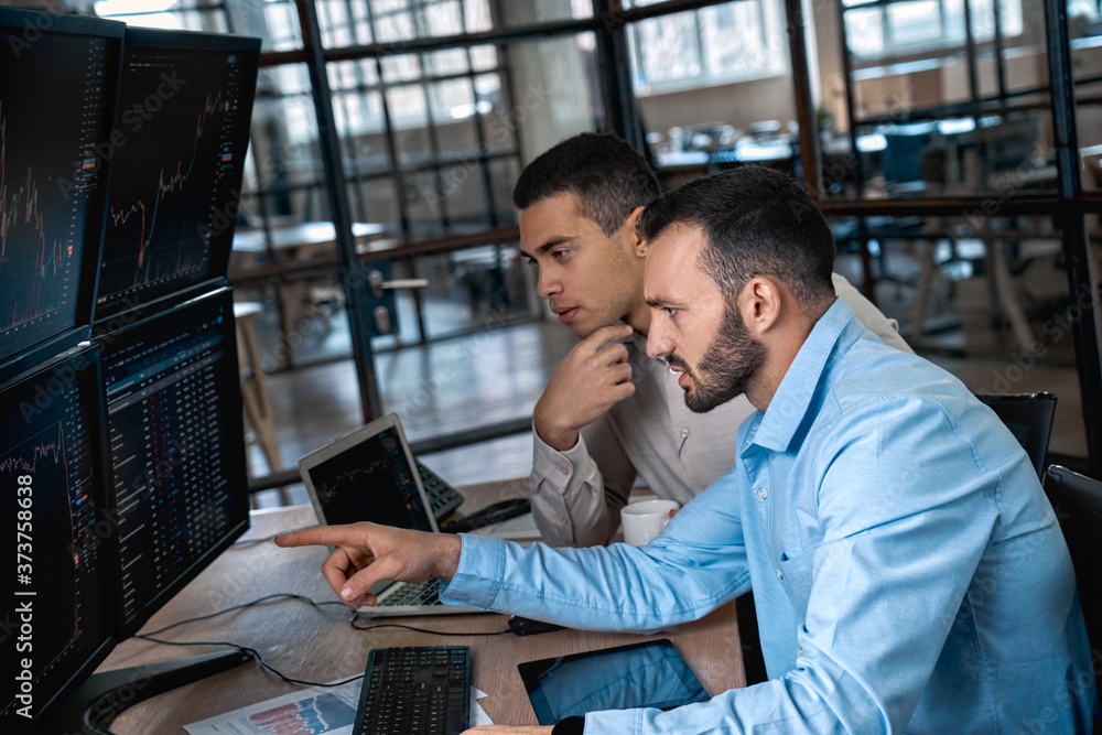 Stock Traiding. Traders sitting at office monitoring market analyzing ...