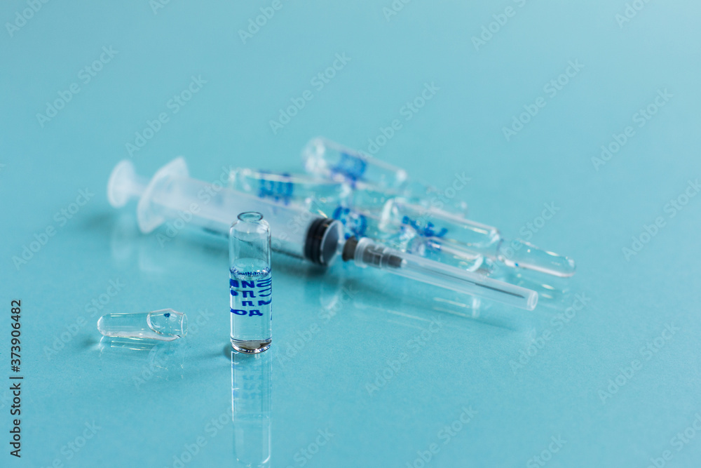 Ampoules for injection and syringes on a blue background . The concept ...