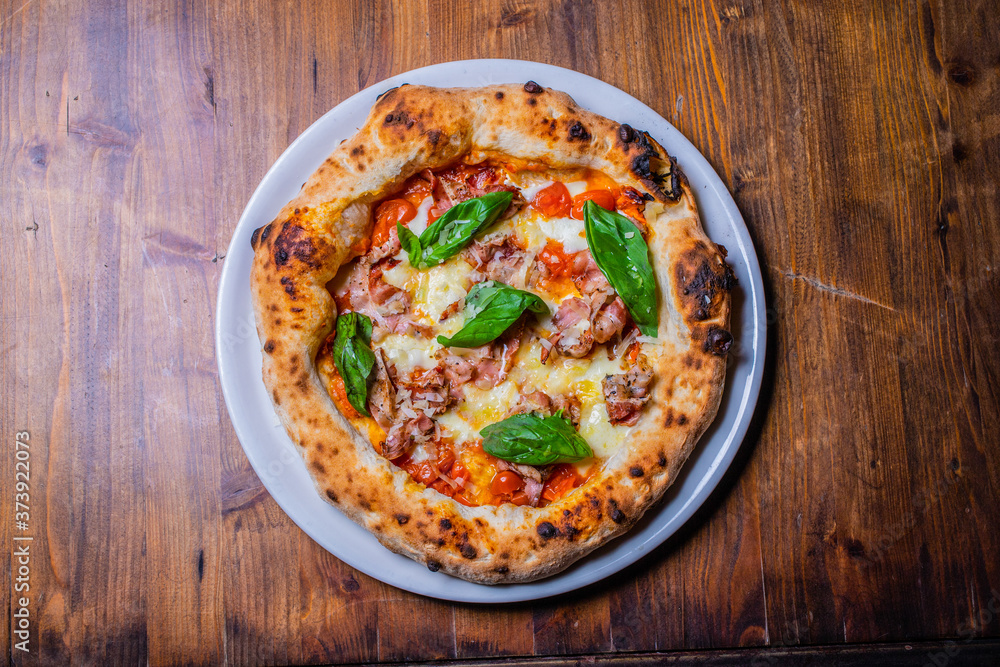 Pizza napoletana con pomodori, mozzarella, basilico e pancetta Stock ...