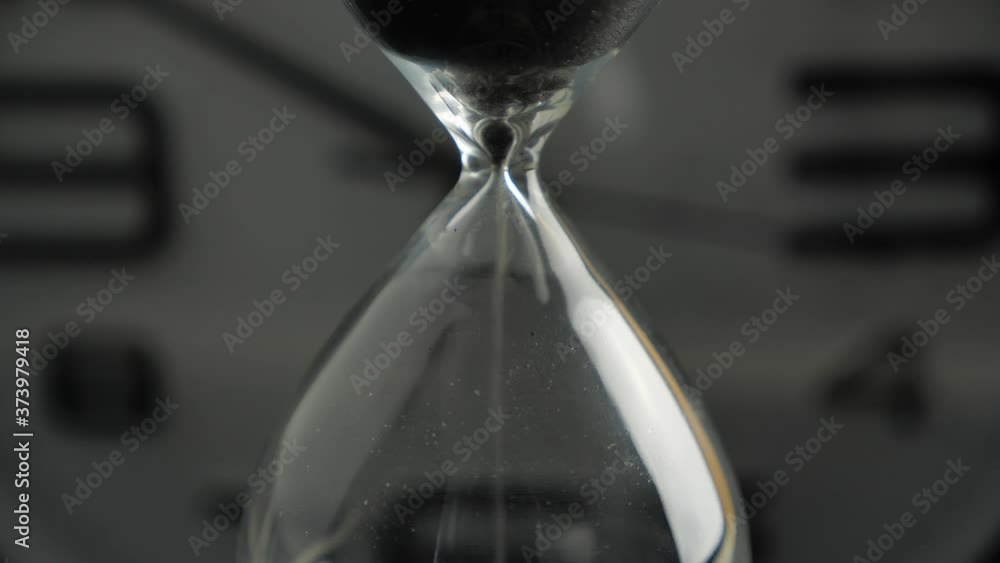 Shot of a sand clock measuring time while the sand is falling down ...