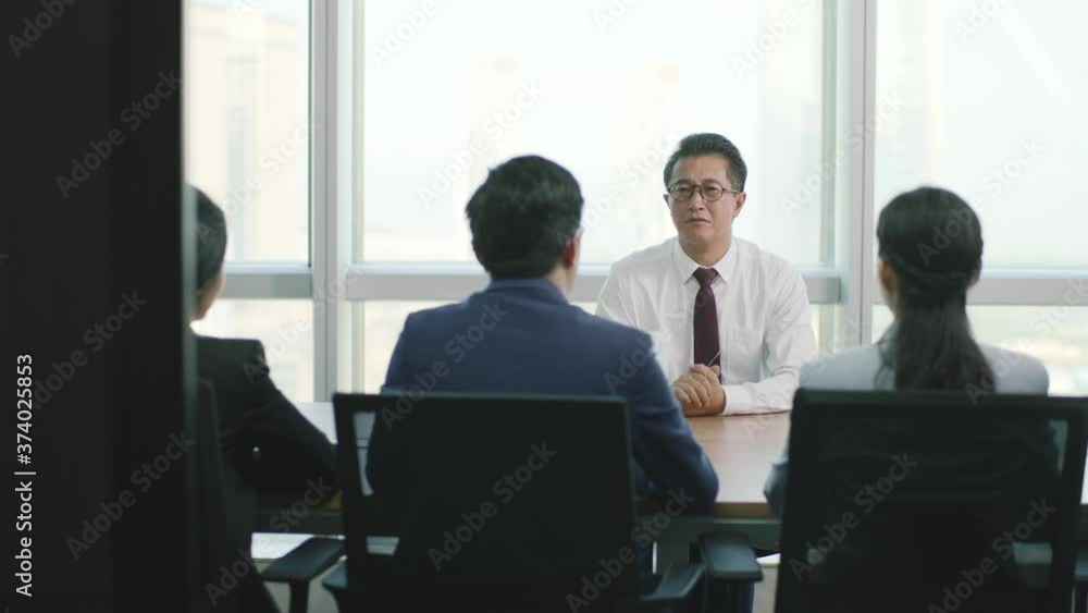 nervous mature asian business man being interviewed by a group of HR ...