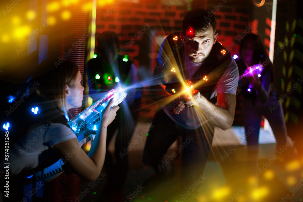 Portrait of excited guy laser tag player with laser pistol in room with ...