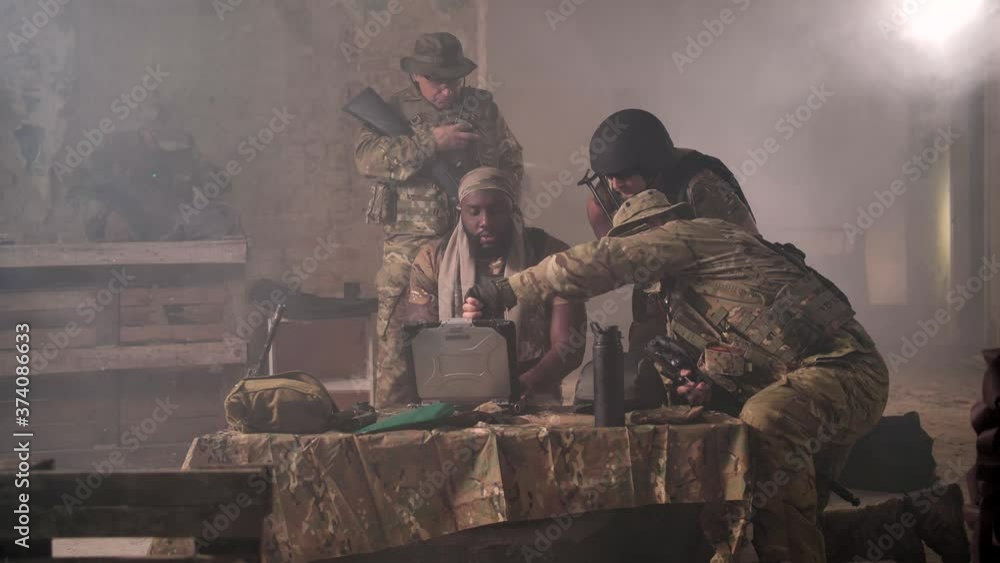 Detachment of military men in camouflage discussing plan of attack and ...