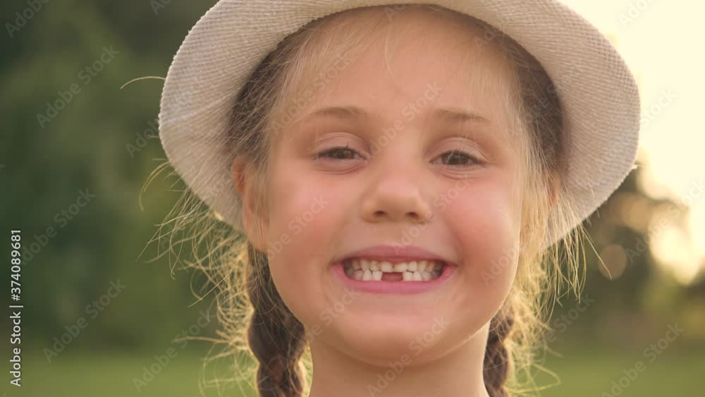 Portrait of a cute girl looking at the camera and smiling. Positive ...