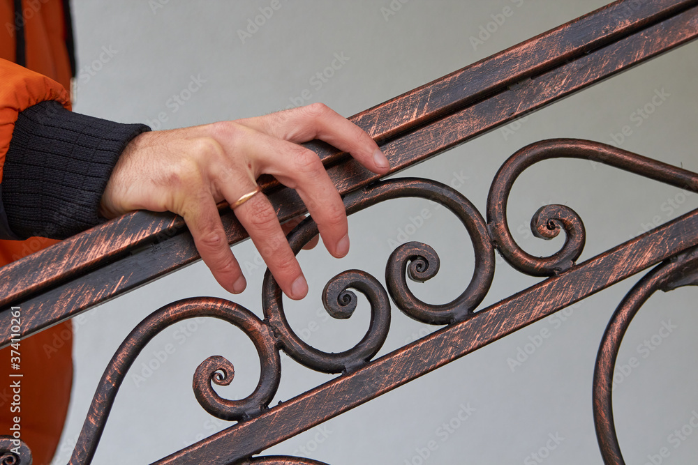 hand on a metal railing, male hand holding the railing on the stairs ...