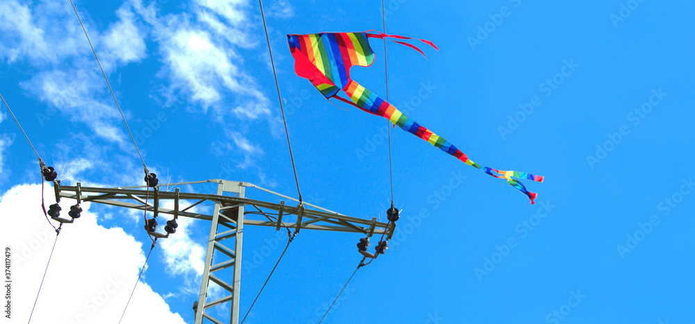 angle view of a colorful and Dangerous Kite flying near electric power ...