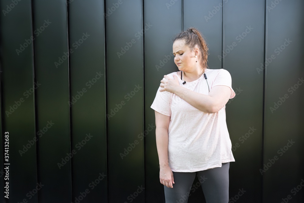 Fat woman suffering with shoulder pain during workout Stock Photo ...