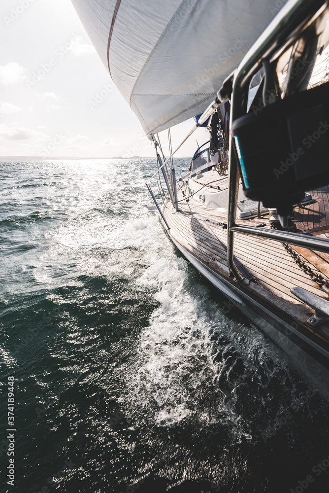 Sloop rigged modern yacht with wooden teak deck racing through the ...