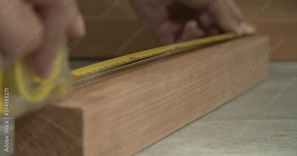 Measuring the size of the wooden board with a tape measure in ...