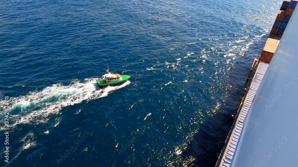 Pilot boat approach to the cargo container ship. Pilot disembark by ...