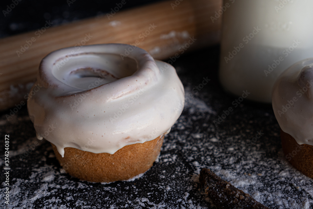 Delicious cinnamon roll glazed with a rolling pin a glass bottle with ...