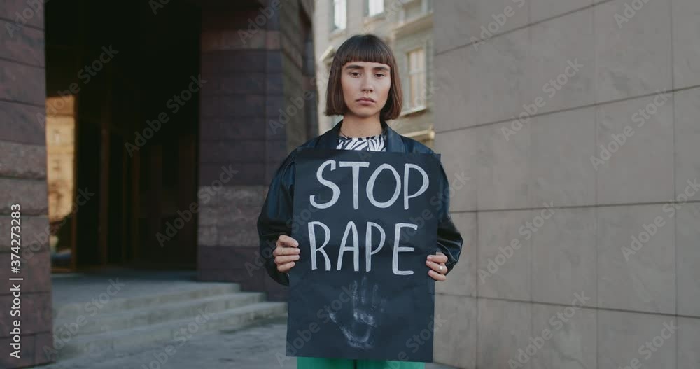 Portrait of millennial girl holding banner with stop rape writing at ...