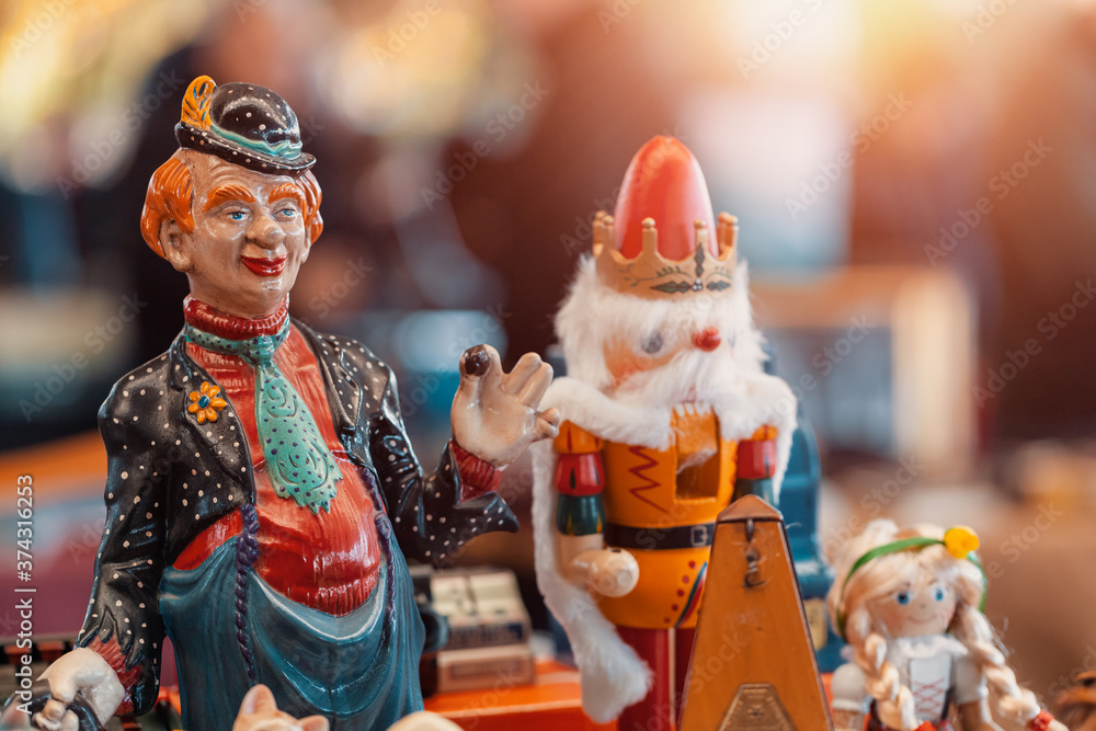 Vintage clown trinket and wooden toys on countertop at antique bazaar ...