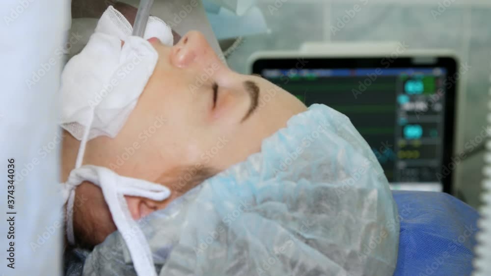 close-up. female patient, in a state of anesthesia, lies on operating ...