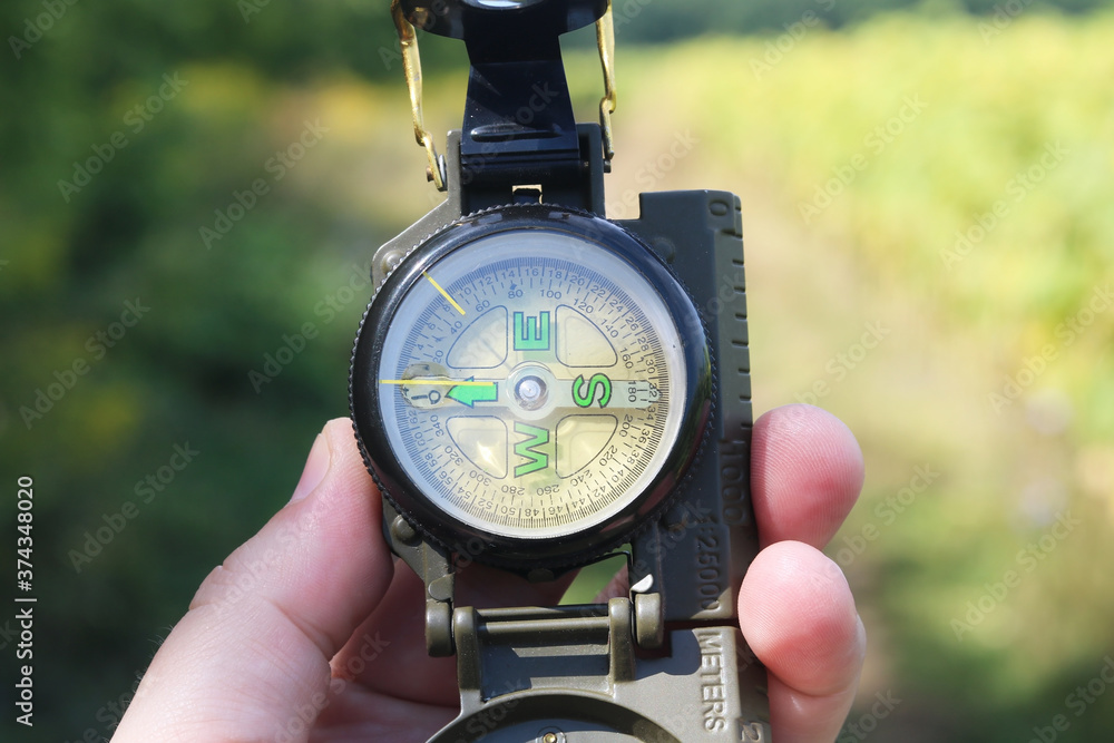 Old classic navigation compass in hand on natural background as symbol ...