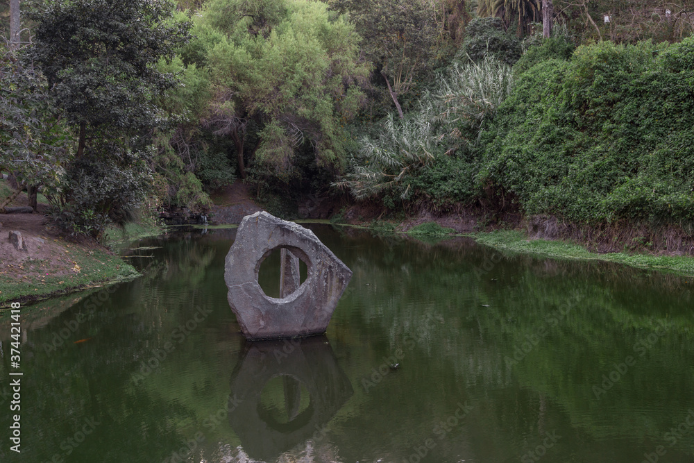 landscape of a lake that has a sculpture made of rock in the middle and ...