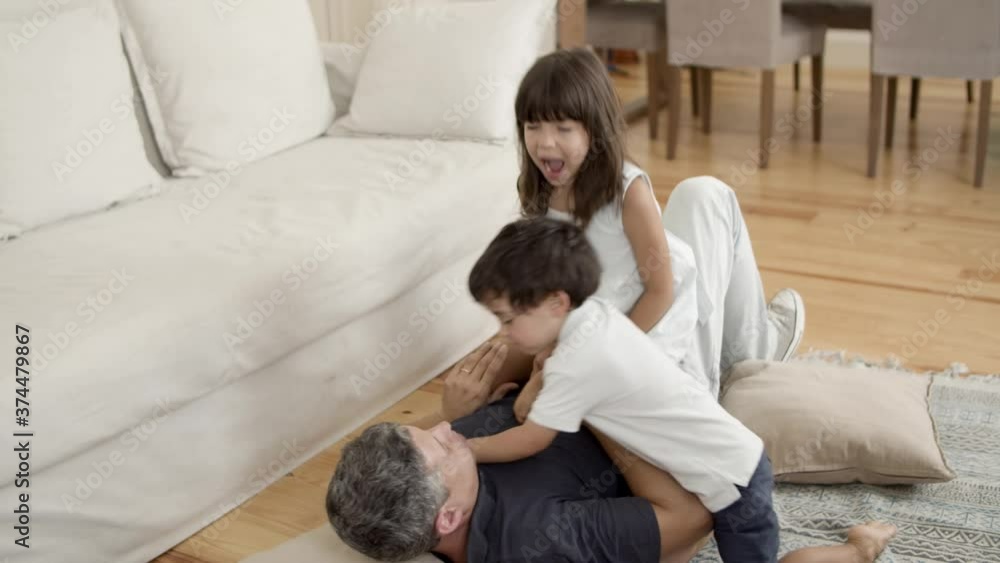 Happy excited dad enjoying leisure time with two kids, cuddling and ...