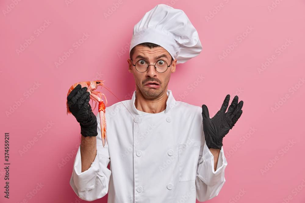 Scared emotional chef holds uncooked crayfish, prepares sea cuisine ...