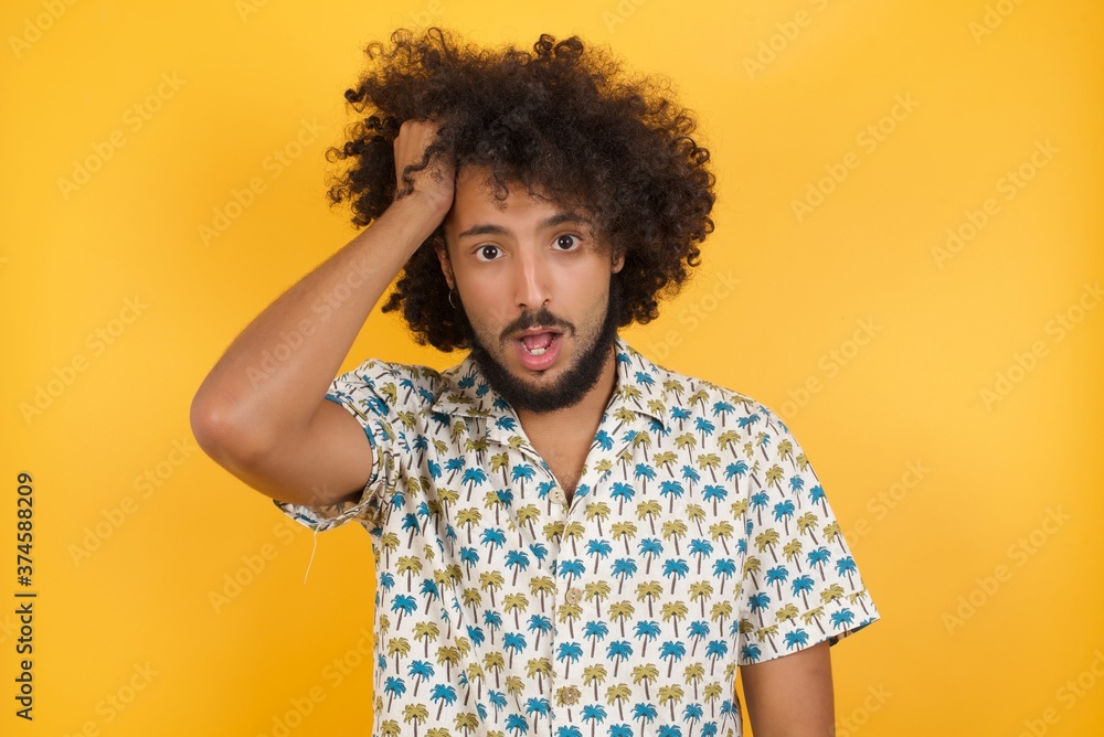 Embarrassed attractive Young man with afro hair wearing hawaiian shirt ...