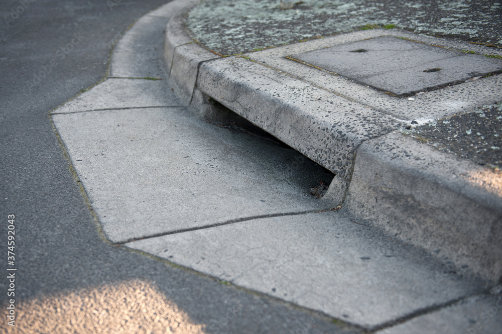 Gutter of a stormwater drainage system in perspective on the side of an ...