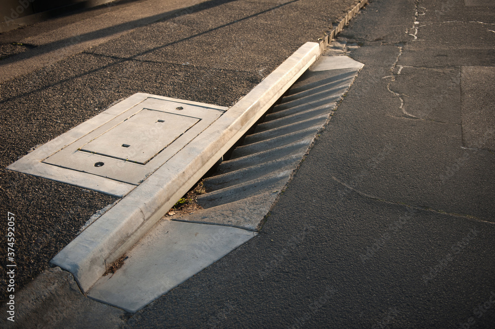 Gutter of a stormwater drainage system in perspective on the side of an ...
