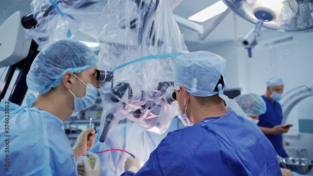 Surgical procedure with microscope. Group of medical specialists in ...