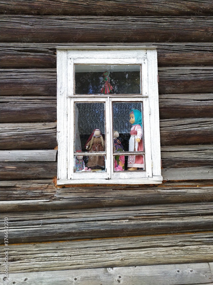 Old dolls in window of olg log wooden village house Stock Photo | Adobe ...