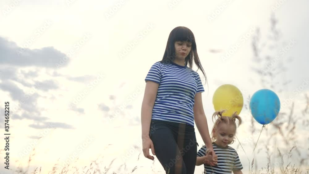 people in the park. happy family daughter and mom go strolling in with ...