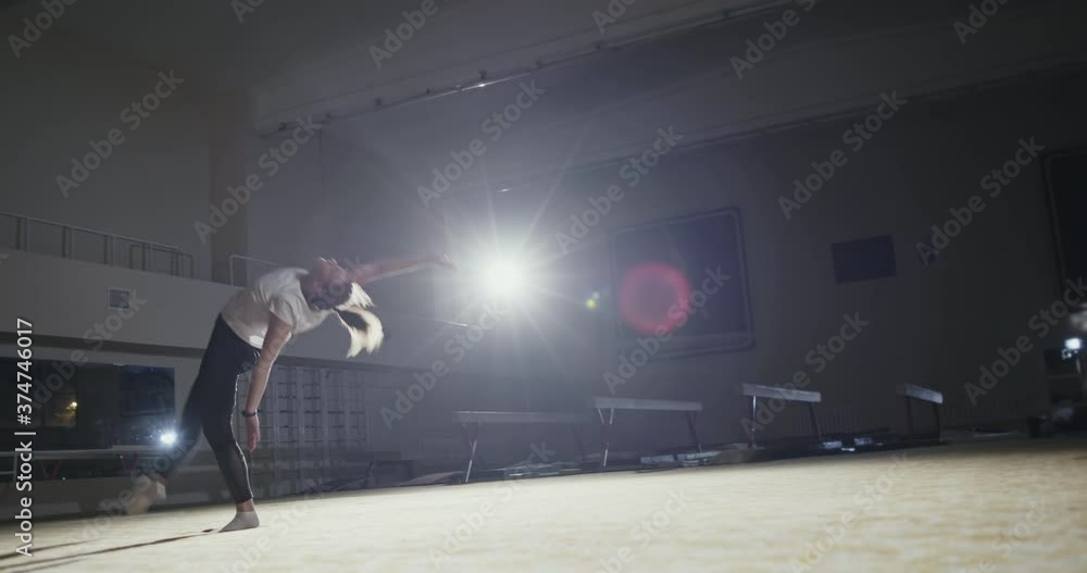 The girl gymnast performs the coup exercise on one arm with the help of ...