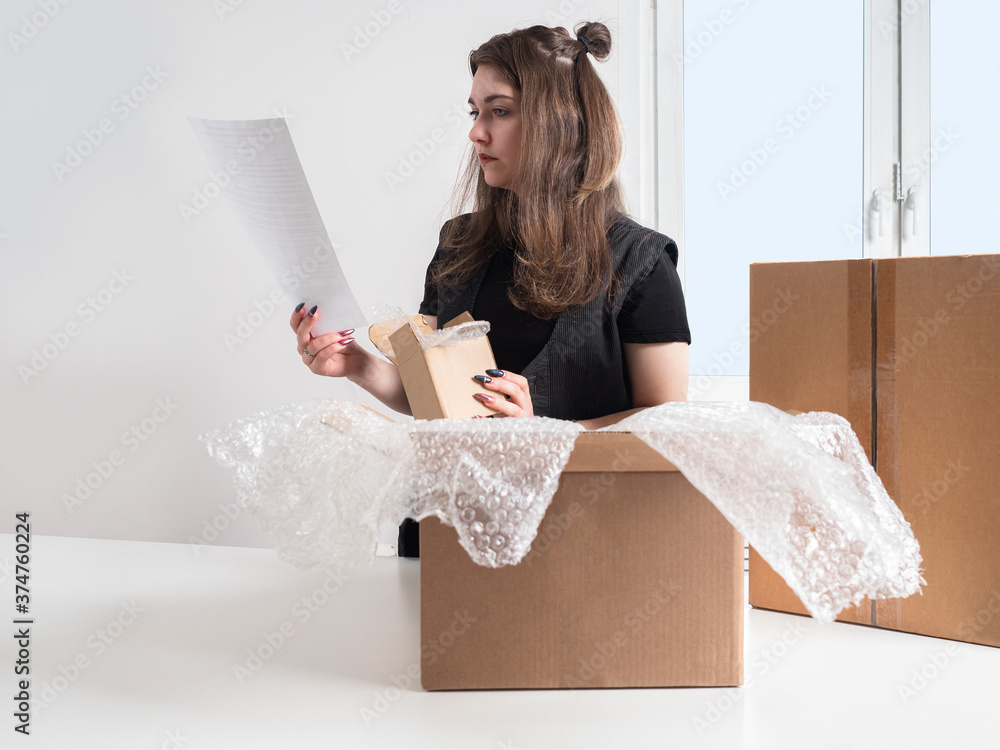 Online store. Dispatch of orders. A girl is packing goods for delivery ...