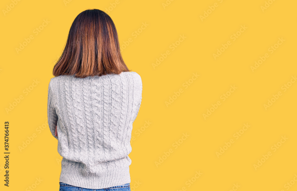 Young beautiful chinese girl wearing casual clothes standing backwards ...
