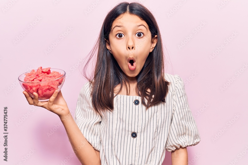Beautiful child girl holding ice cream scared and amazed with open ...