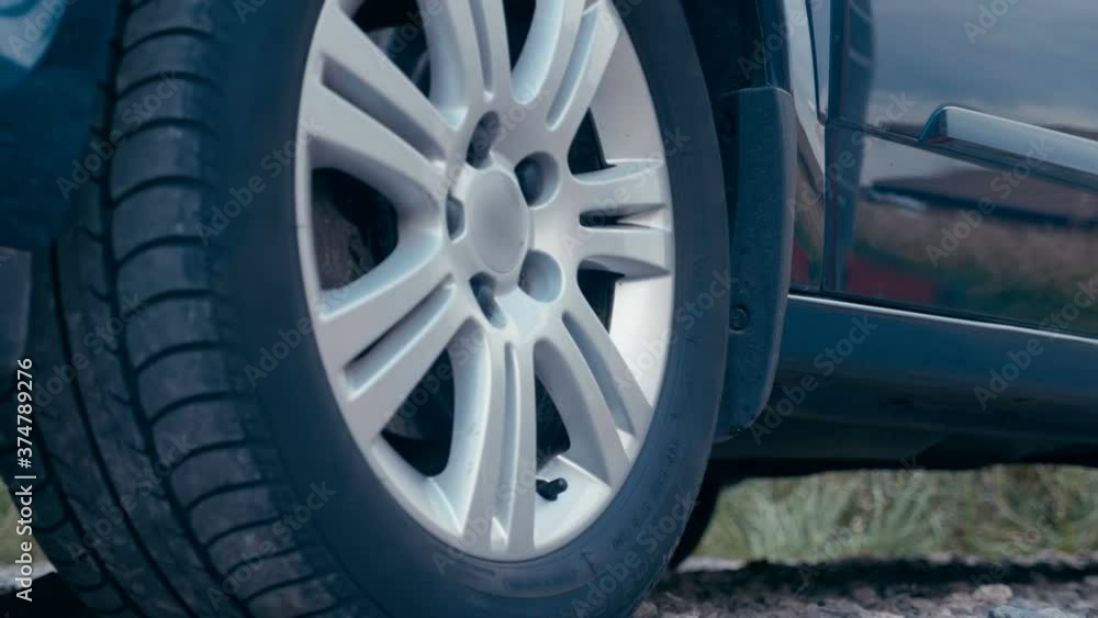 The blue car starts and drives slowly, shiny silver rims shine in the ...