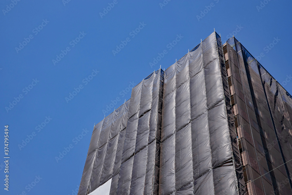 High rise tower block under construction and covered with scaffold ...