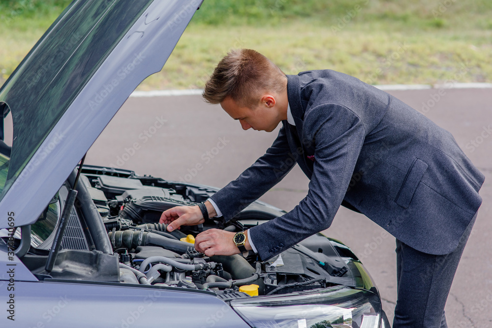 Car breakdown. side view of Concentrated young man try to repair the ...