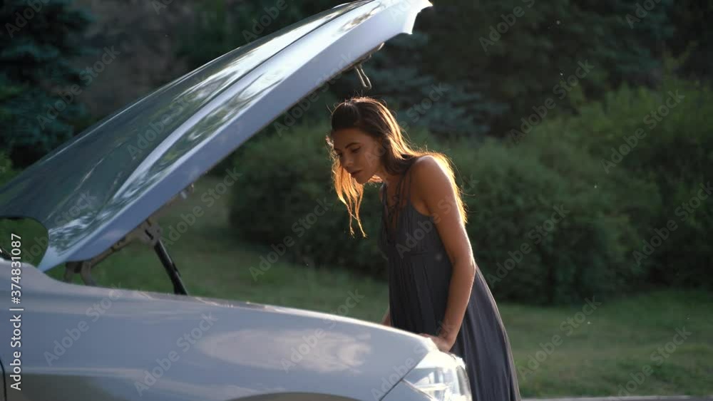 woman trying to repair her engine, Young upset woman standing at broken ...