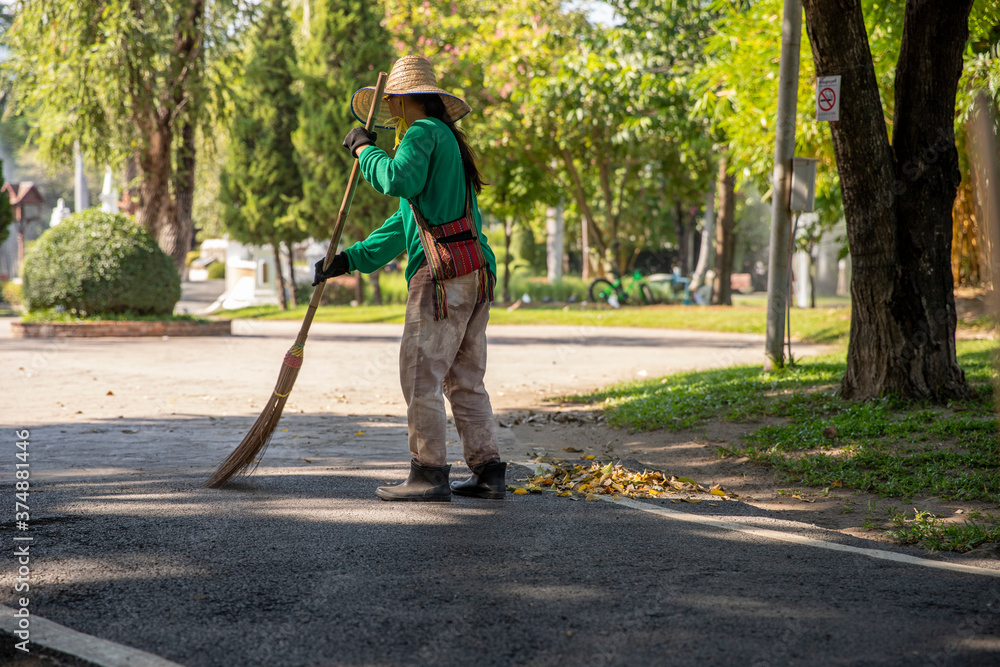 Workers are sweeping the pavement with broom that fall on the street in ...