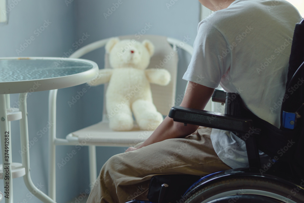 Asian special child on wheelchair with his good friend is teddy bear ...