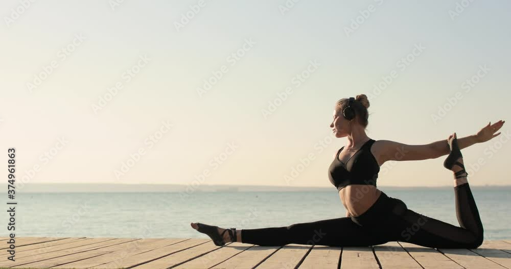 Stretching and yoga concept. Sporty woman is doing longitudinal split ...