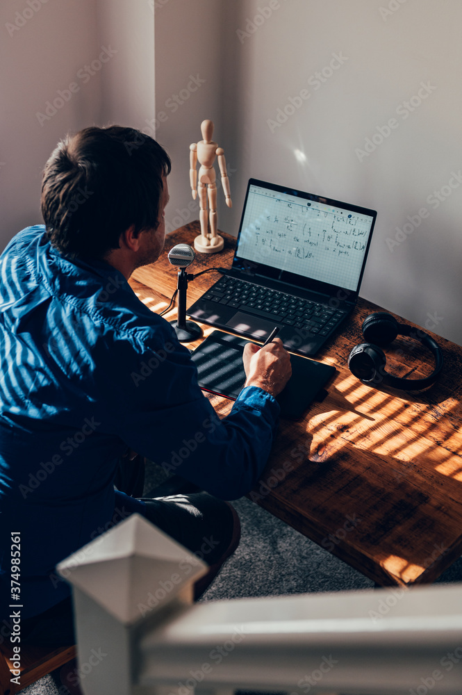 Young university professor is doing online lecture for his students ...