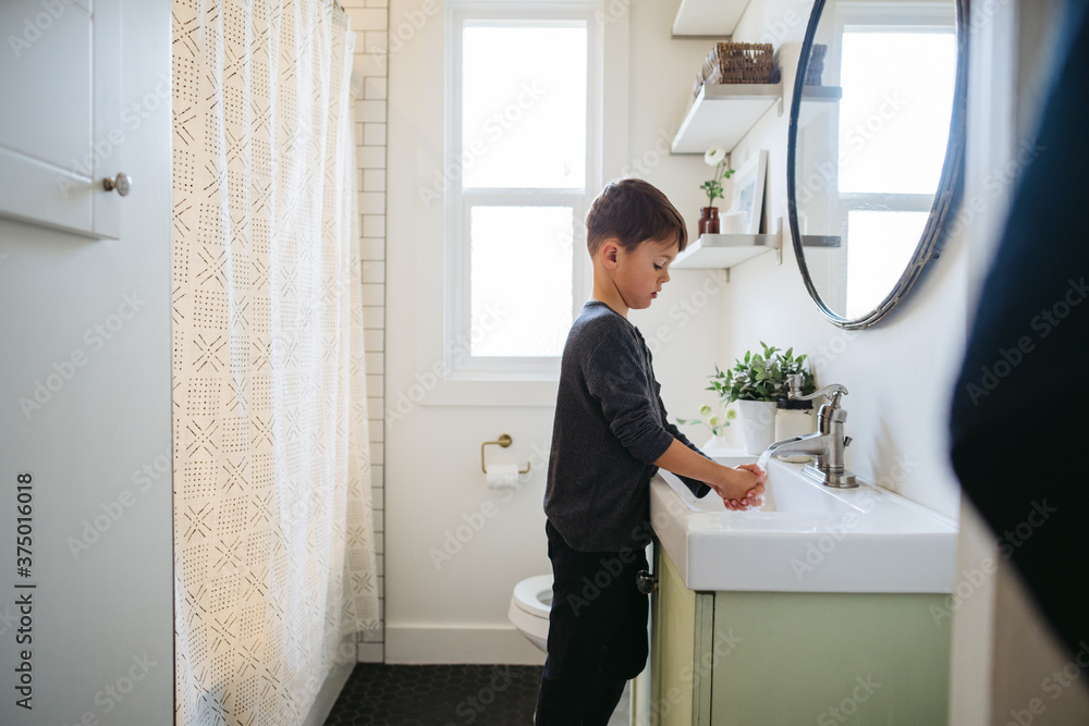 Young boy washing hands in bathroom at home. Stock Photo | Adobe Stock