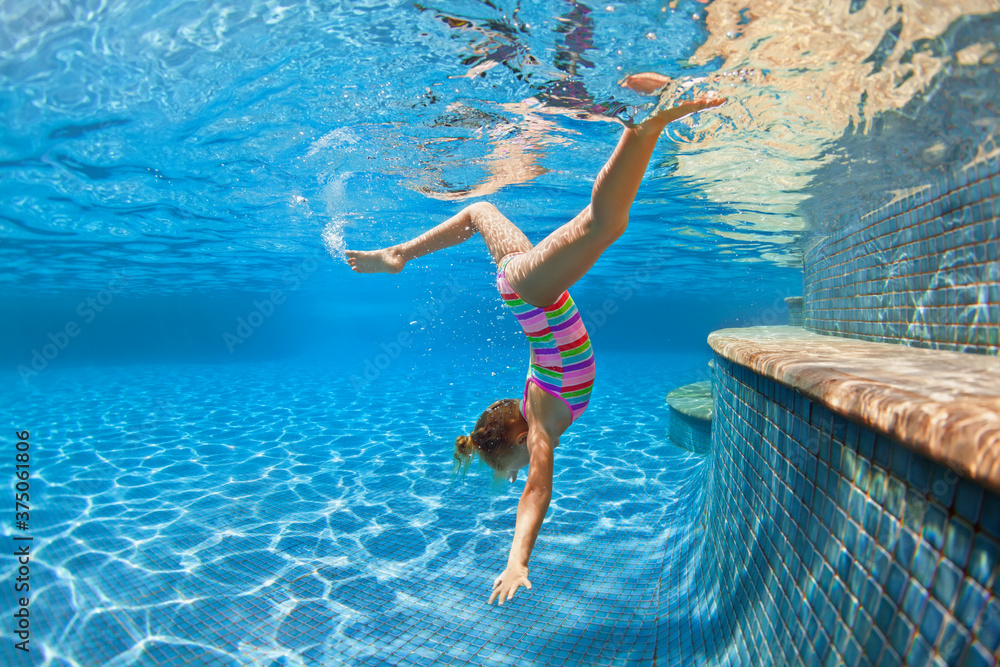 Foto Stock Funny portrait of child learning swimming, dive in blue pool ...