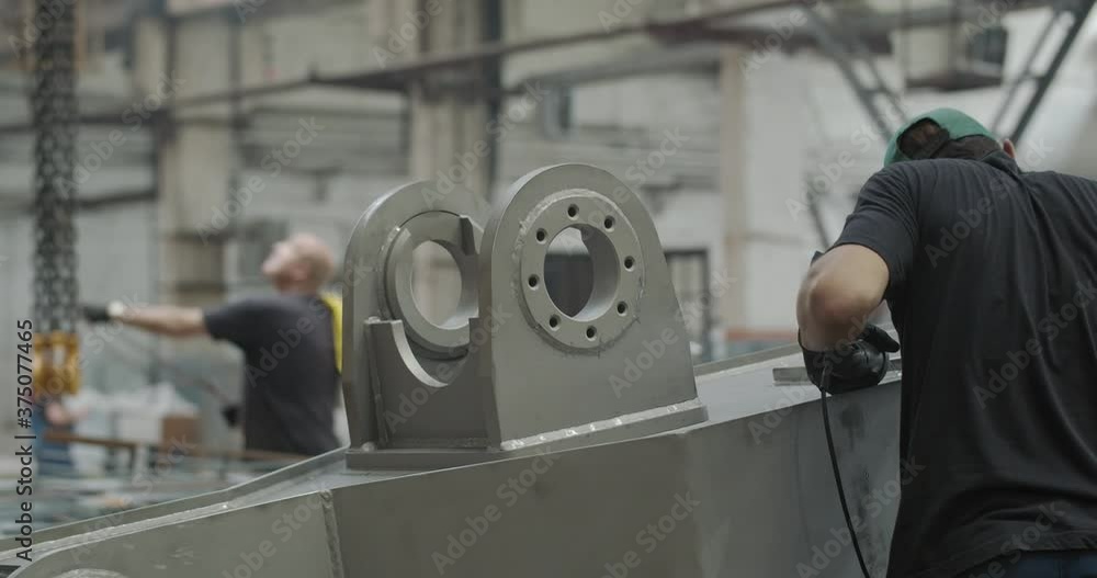 Factory workers at work, polishing the parts of a mud gun machine, 4k ...