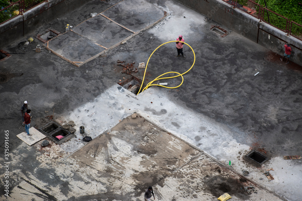 Labour worker inserting drainage and electrical pipe in inspection ...