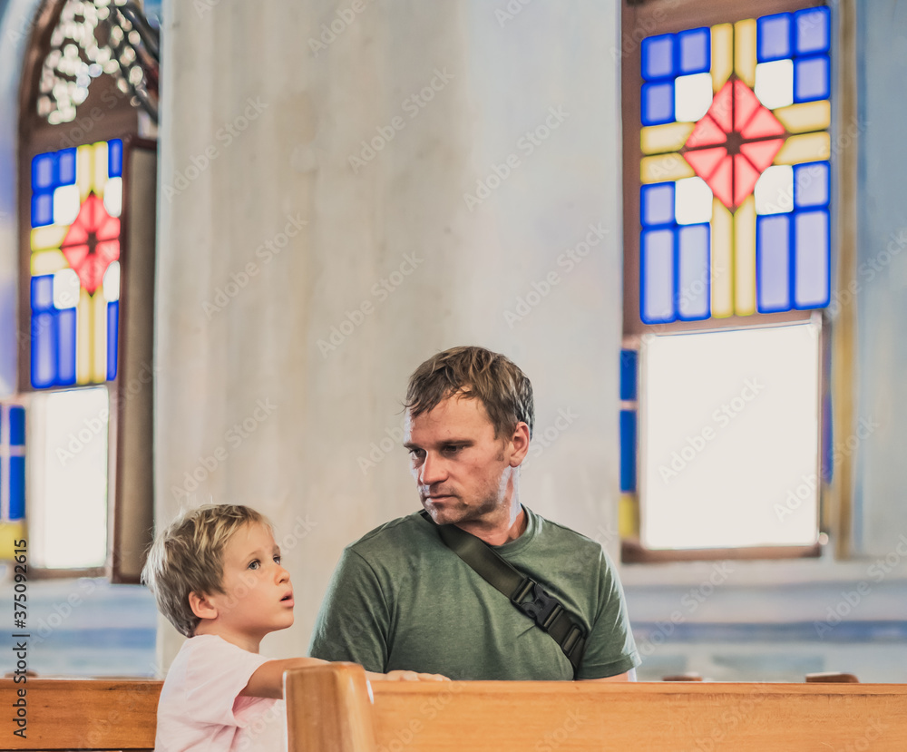 Christian dad tells his son Bible stories about Jesus sitting in kirk ...