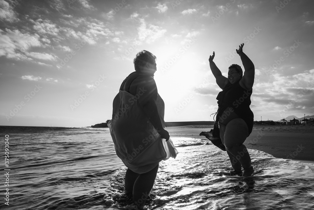 Plus size women dancing on the beach having fun during summer vacation ...