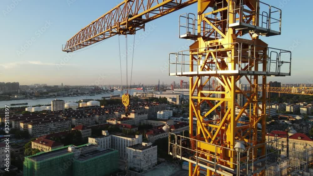 Drone point of view moving up around crane tower in construction site ...