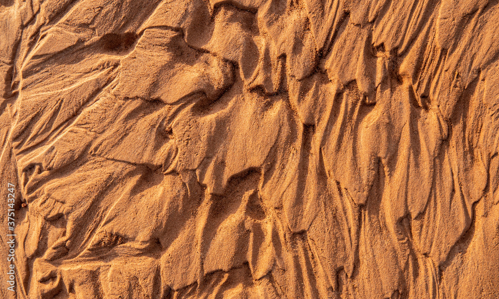 Nature closeup background of dry sand after water flows with shadows ...